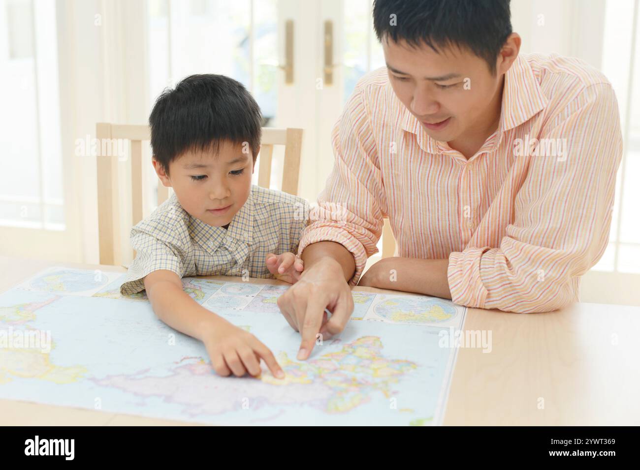 Father and child spreading map at table Stock Photo - Alamy