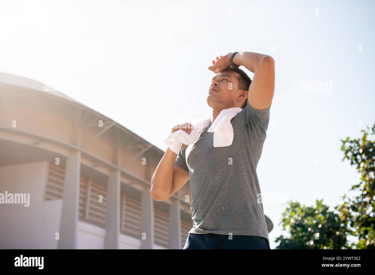 A portrait of a tired, sweaty Asian man in sportswear, exhausted from ...