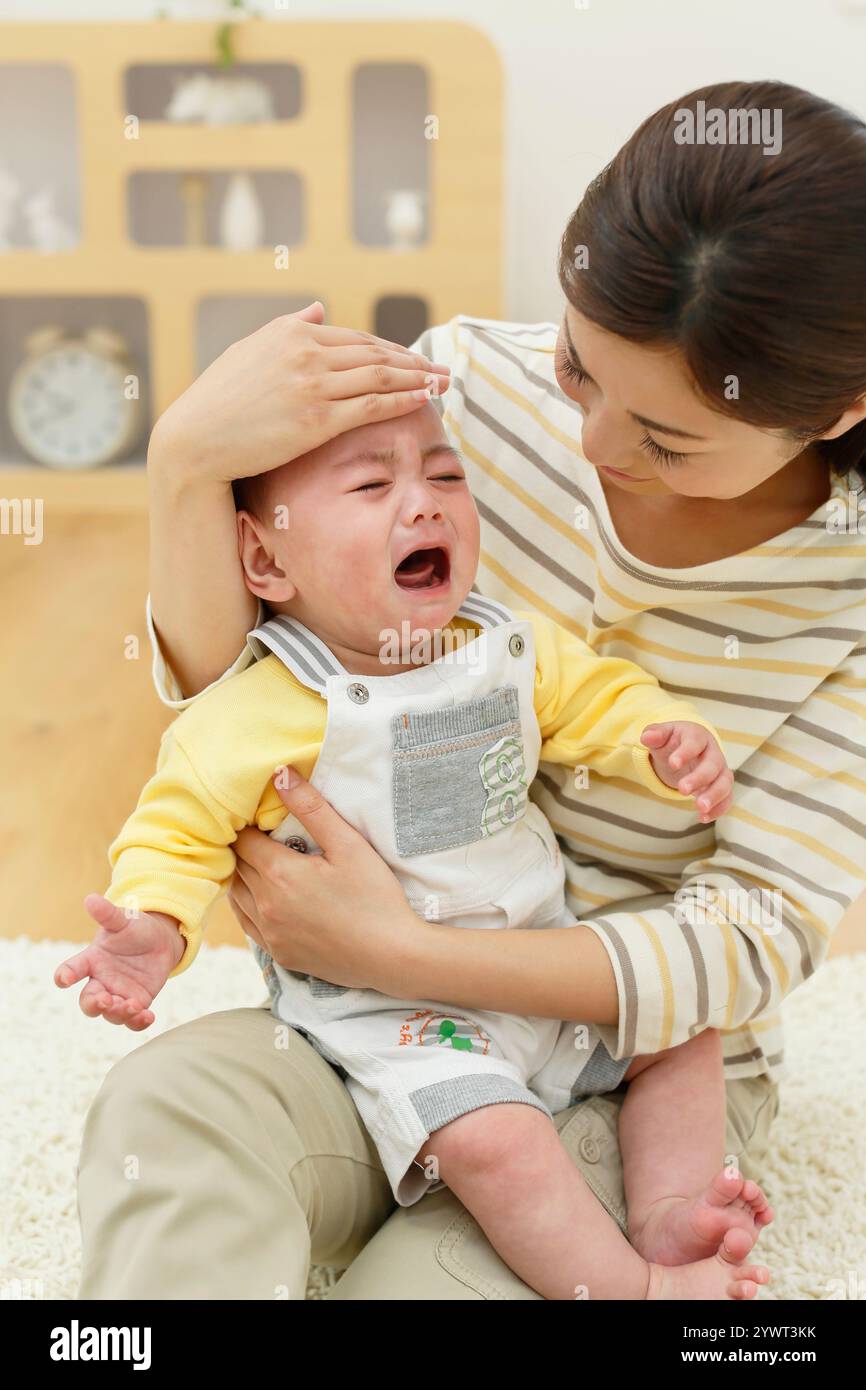Baby who is unwell and mother taking a temperature Stock Photo - Alamy