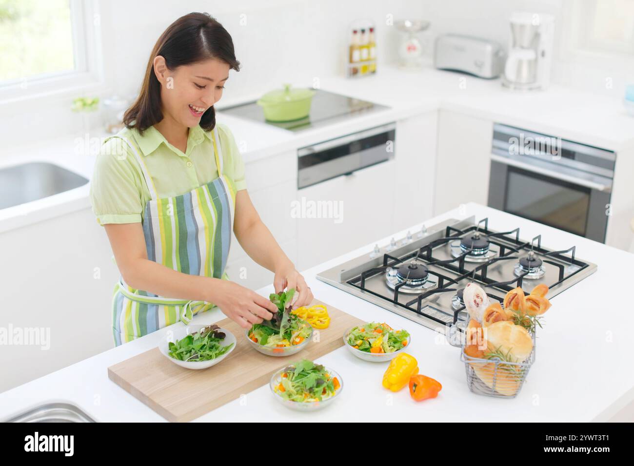 Woman cooking in a well-lit kitchen Stock Photo - Alamy