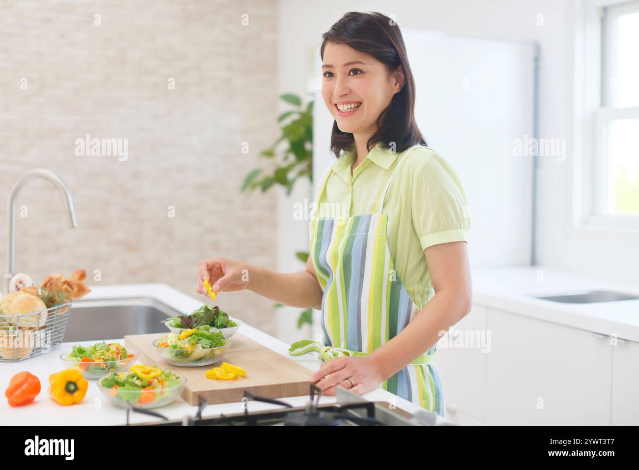 Woman cooking in a well-lit kitchen Stock Photo - Alamy