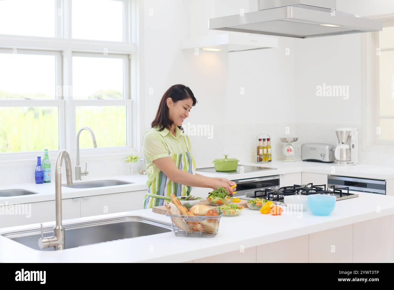 Woman cooking in a well-lit kitchen Stock Photo - Alamy