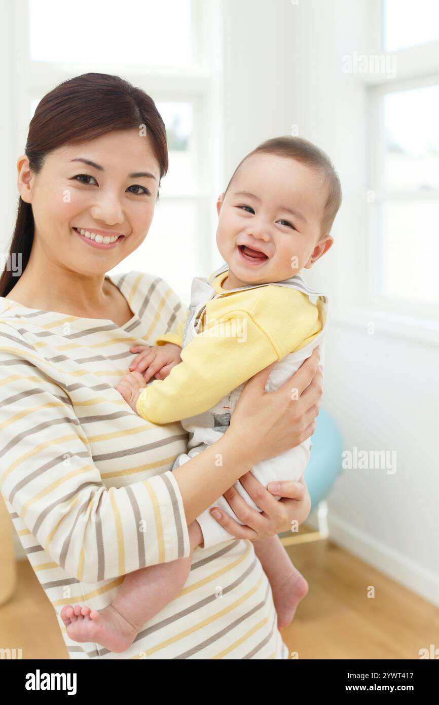 Baby being carried by mother Stock Photo - Alamy