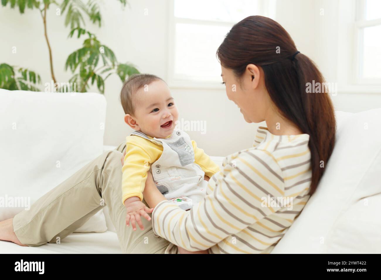 Mother and baby interacting on sofa Stock Photo - Alamy