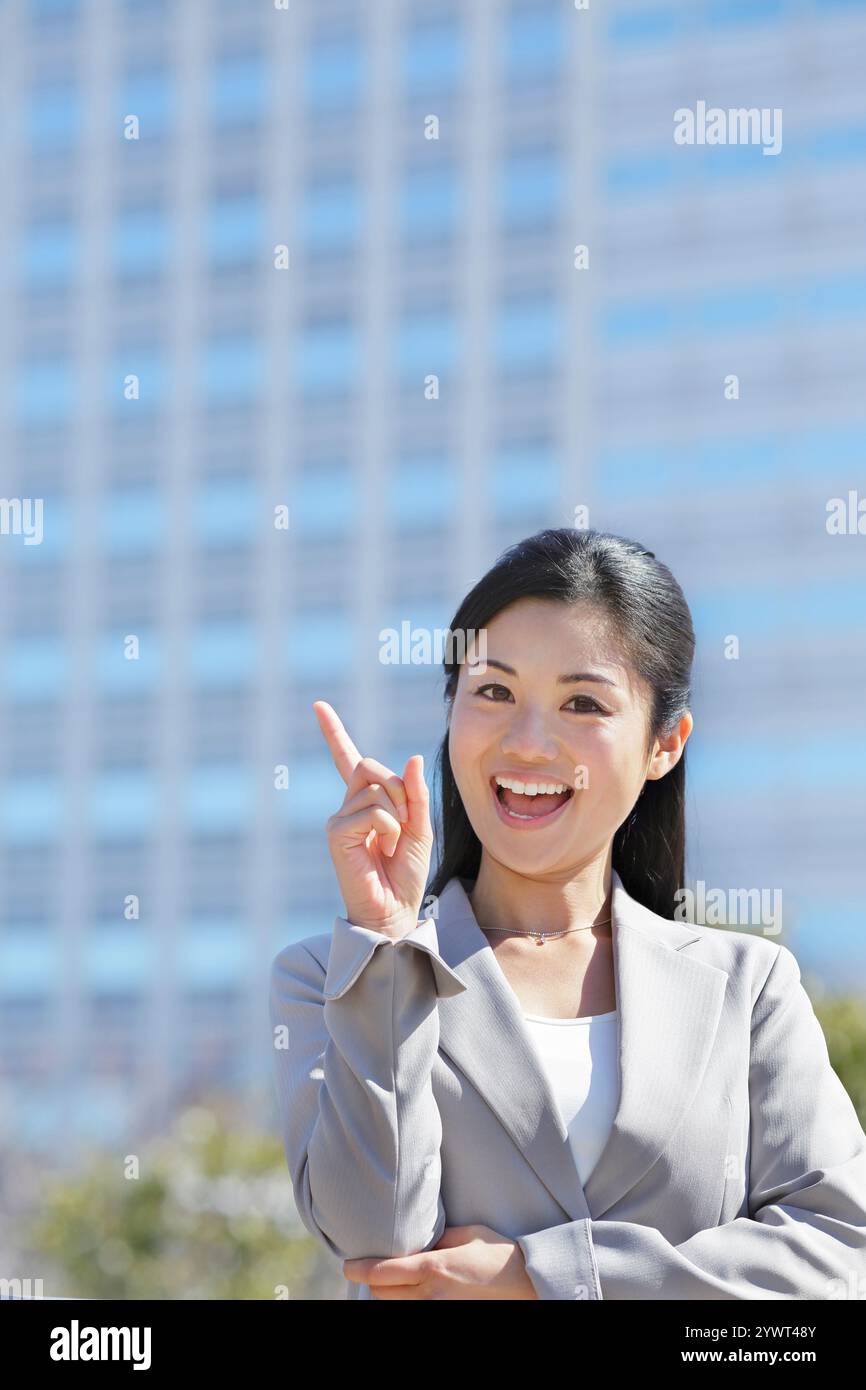Businesswoman pointing and posing in a building block Stock Photo - Alamy