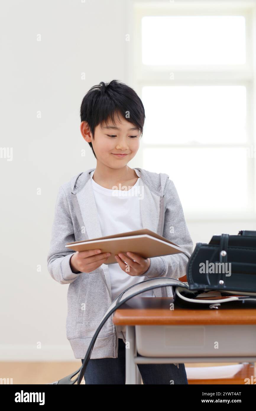 Boy getting ready to leave school in classroom Stock Photo - Alamy