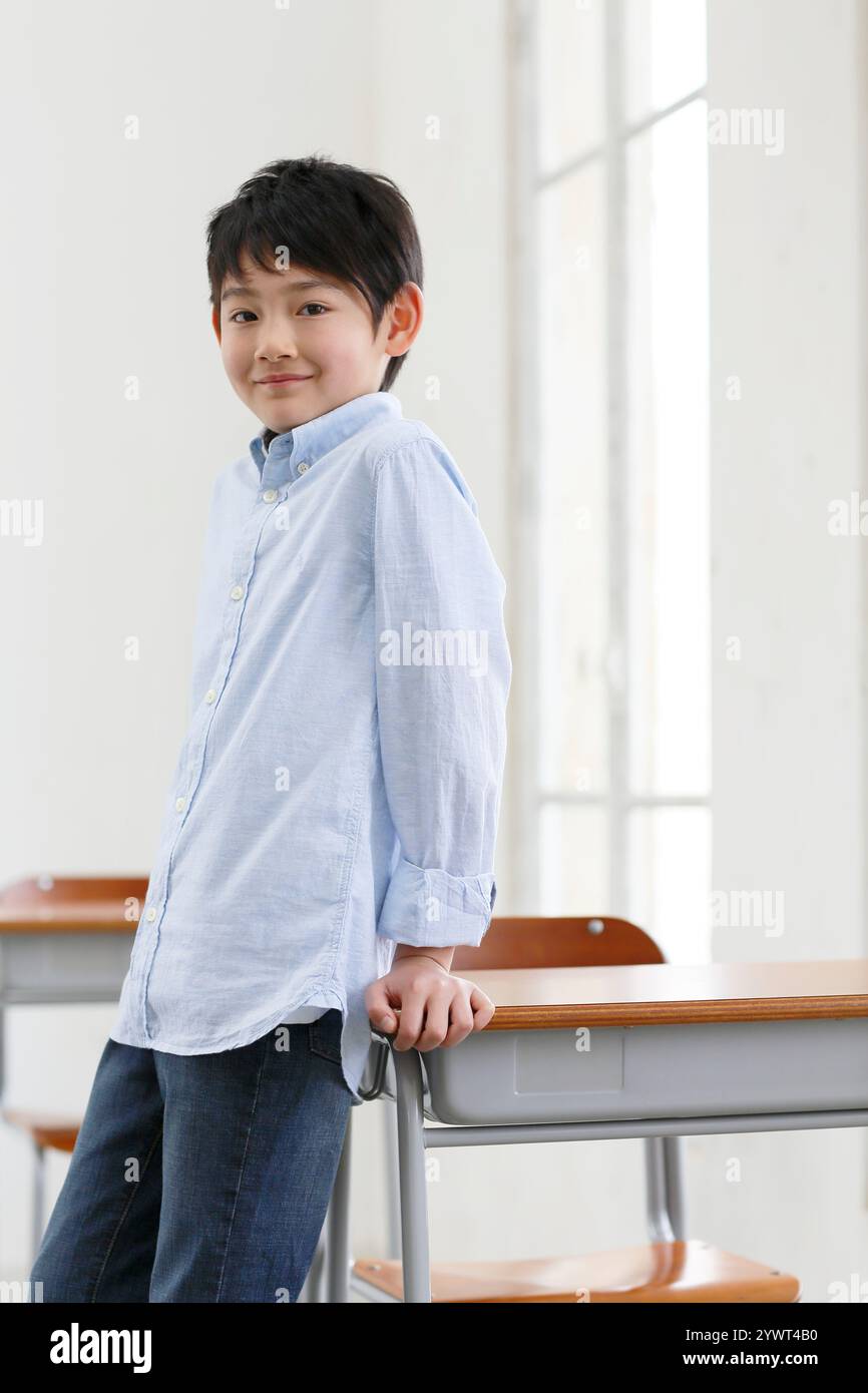 Boy standing in classroom Stock Photo - Alamy