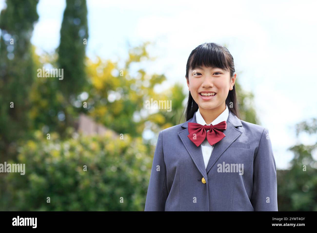Girl in school uniform standing in spring garden Stock Photo - Alamy