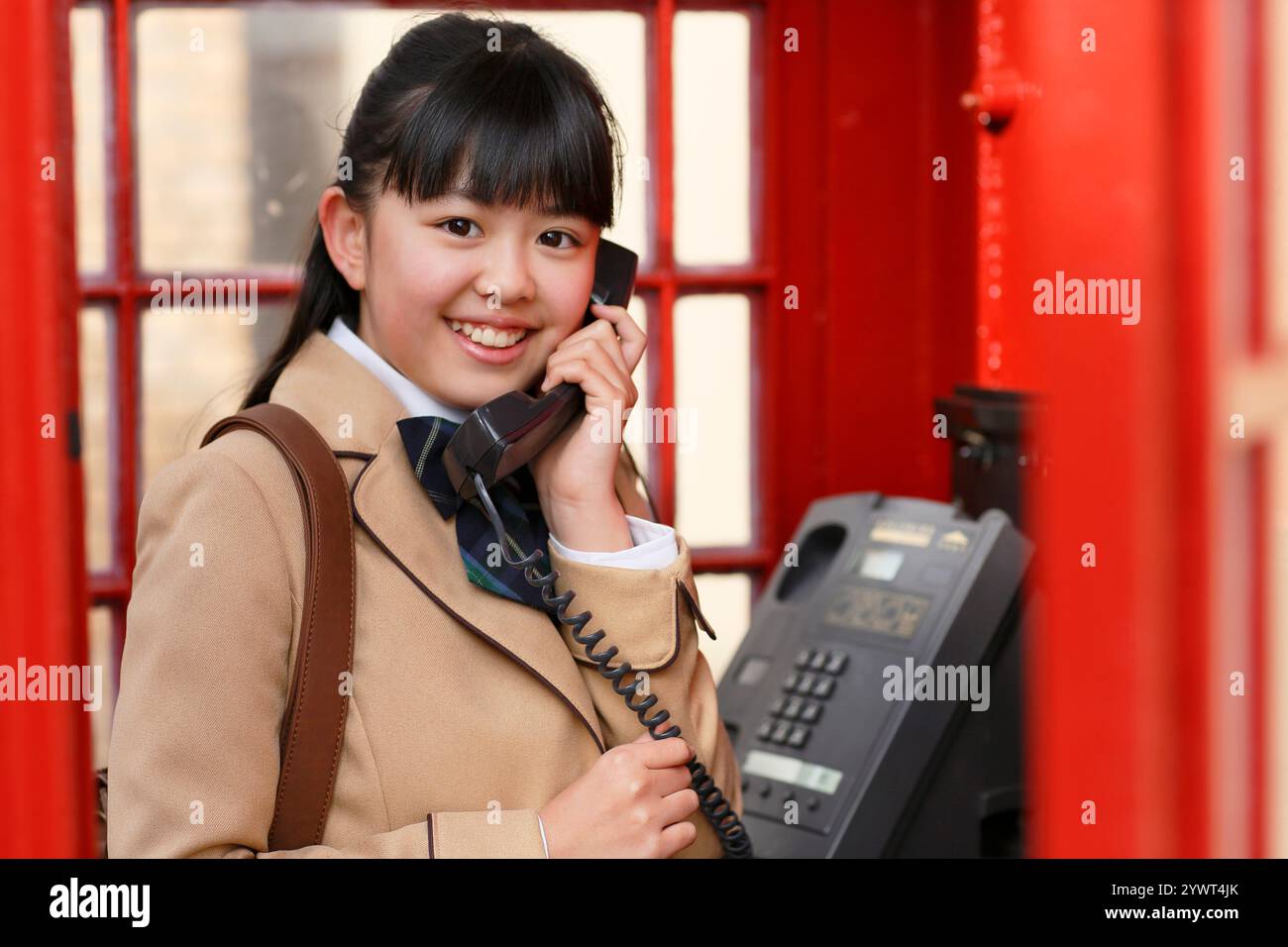 Red telephone booth and girl in uniform Stock Photo - Alamy