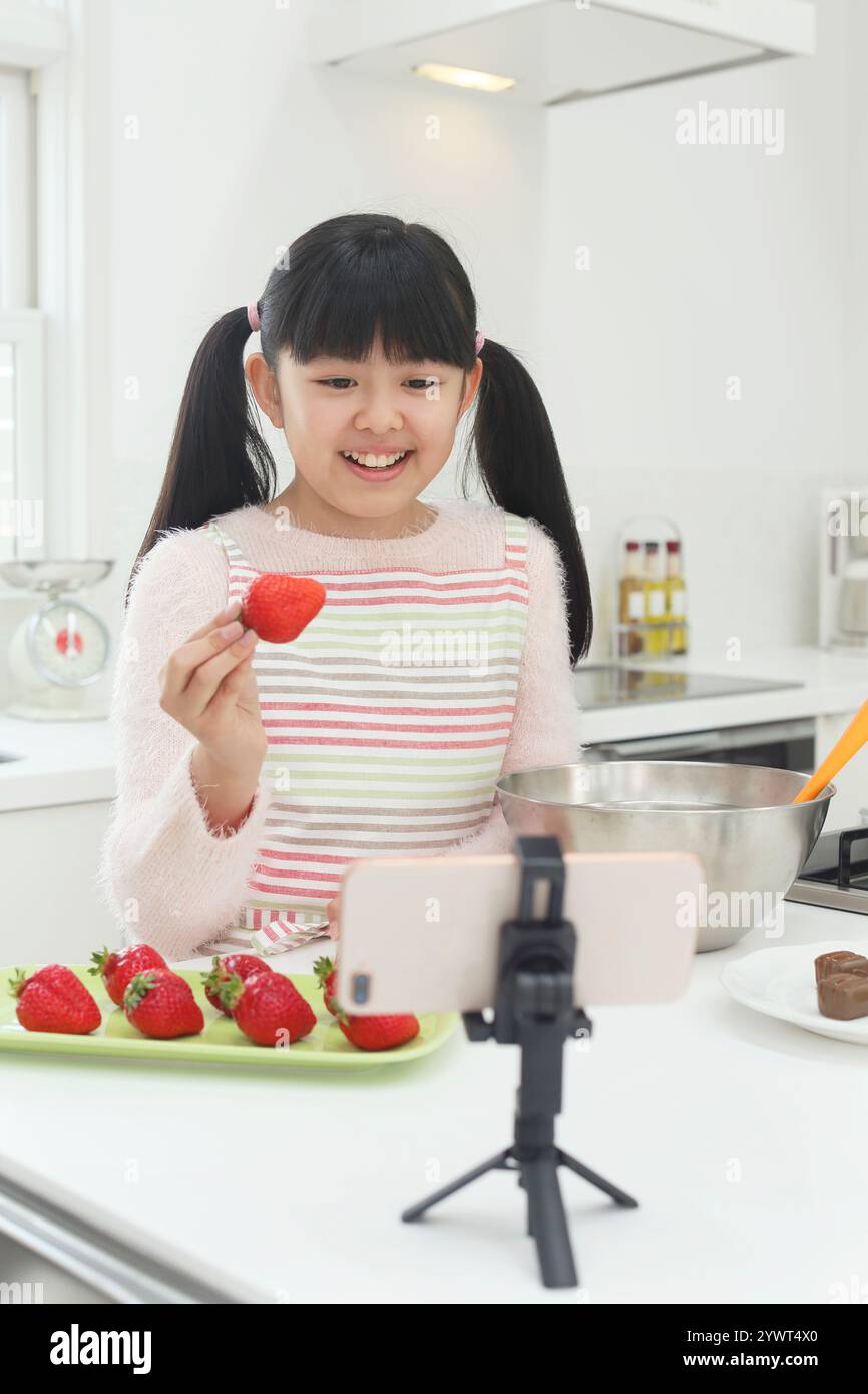 Small you-tubers explaining how to make sweets Stock Photo - Alamy