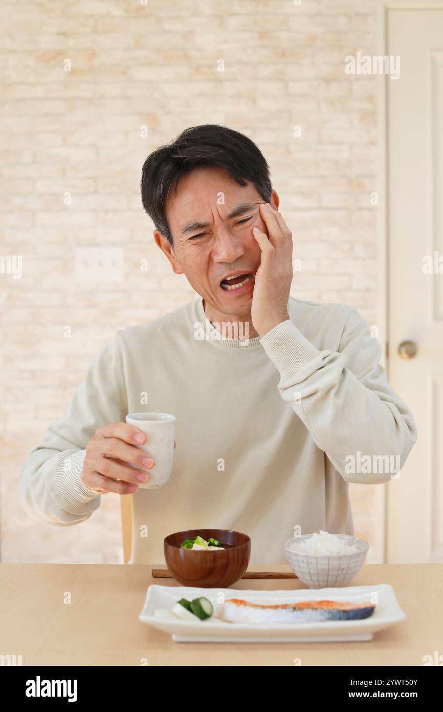 Middle-aged man with toothache twisting his face Stock Photo - Alamy