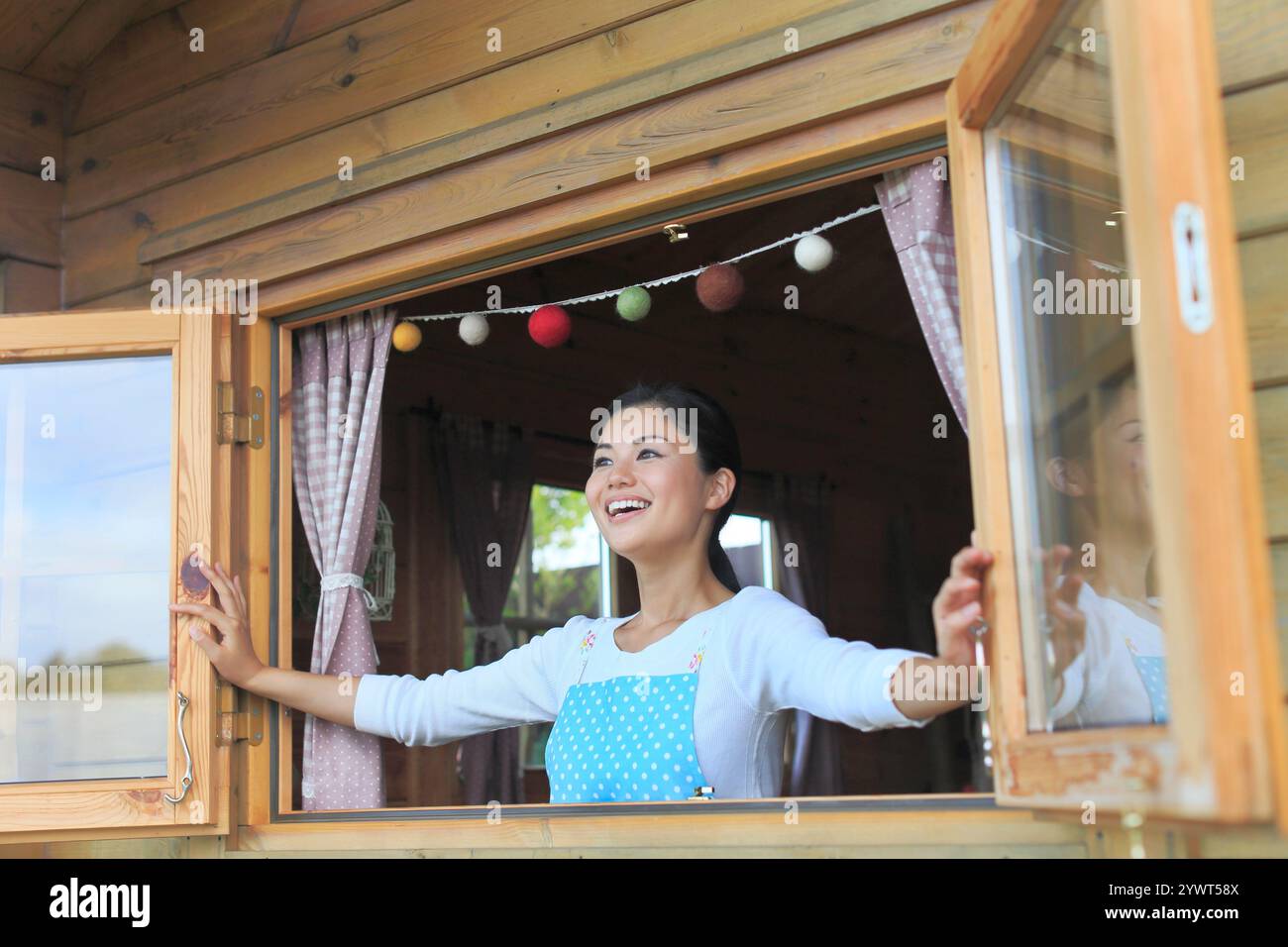Woman opening a window of a house Stock Photo - Alamy