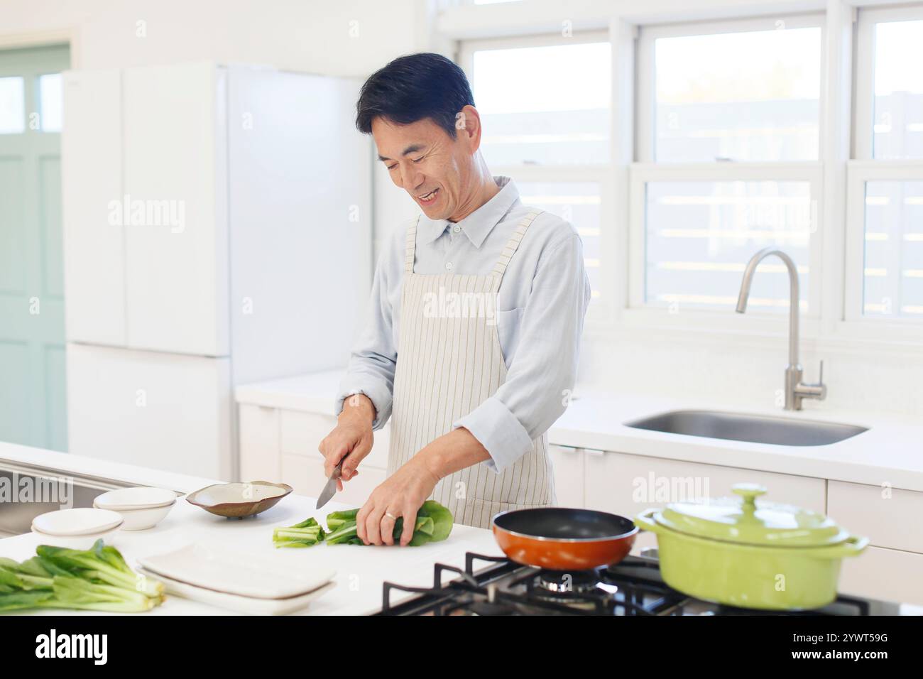 Middle-aged man cooking with apron Stock Photo - Alamy
