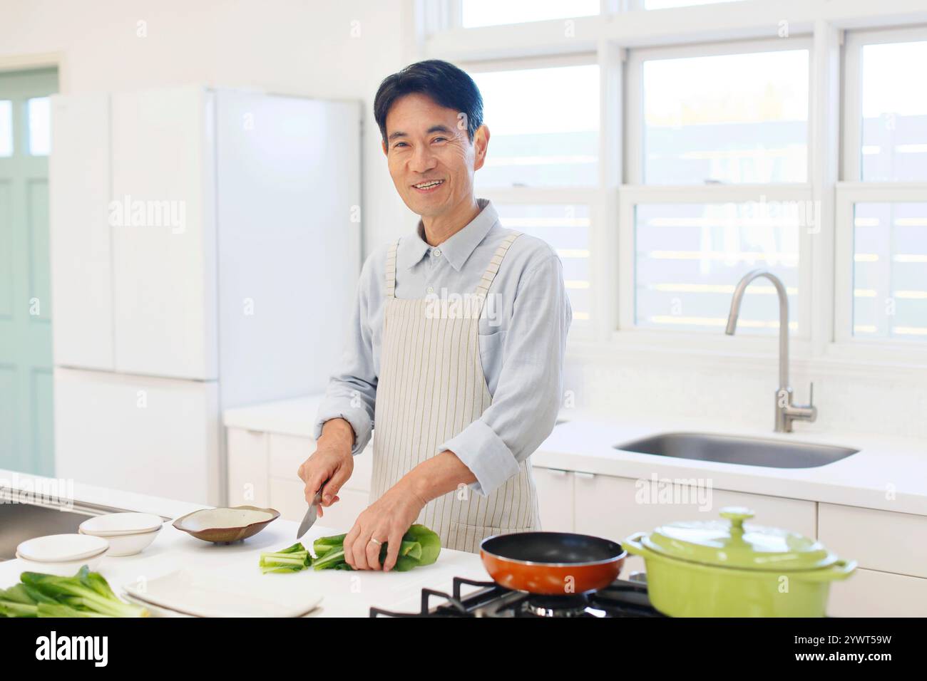 Middle-aged man cooking with apron Stock Photo - Alamy
