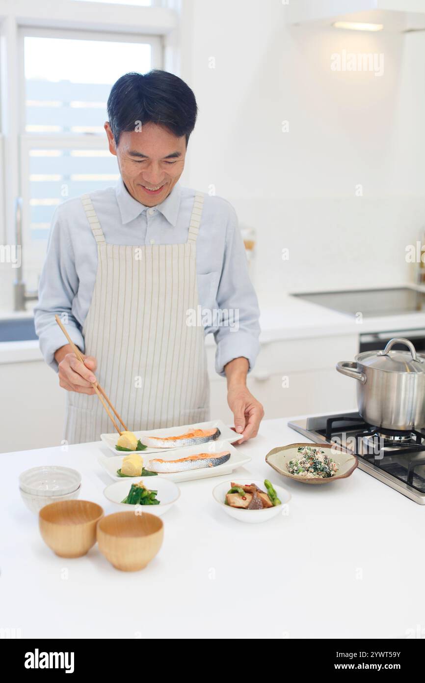 Middle-aged man cooking with apron Stock Photo - Alamy