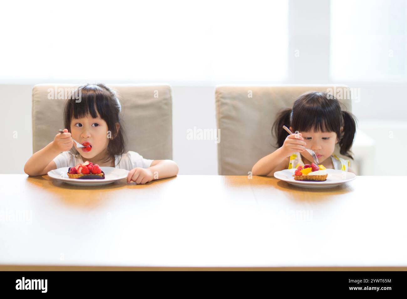 Two girls eating cake Stock Photo - Alamy