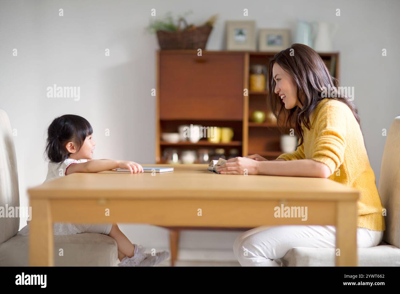 Parent and child relaxing at dining table Stock Photo - Alamy