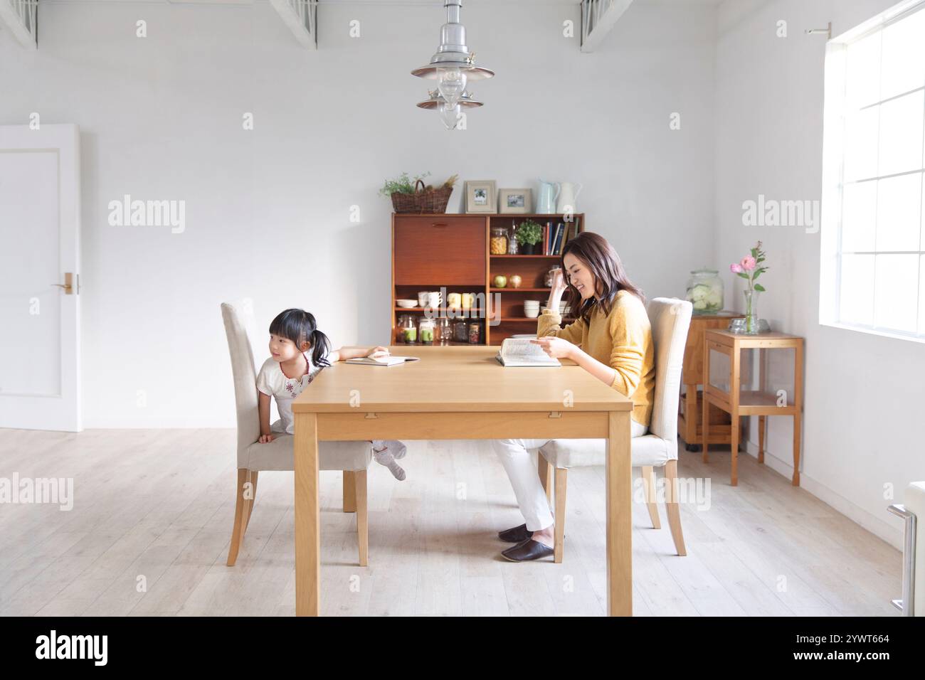 Parent and child relaxing at dining table Stock Photo - Alamy