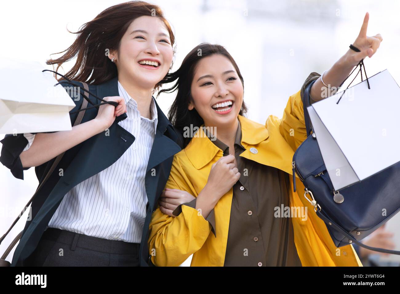 Two women smiling in the direction of the pointing finger Stock Photo ...