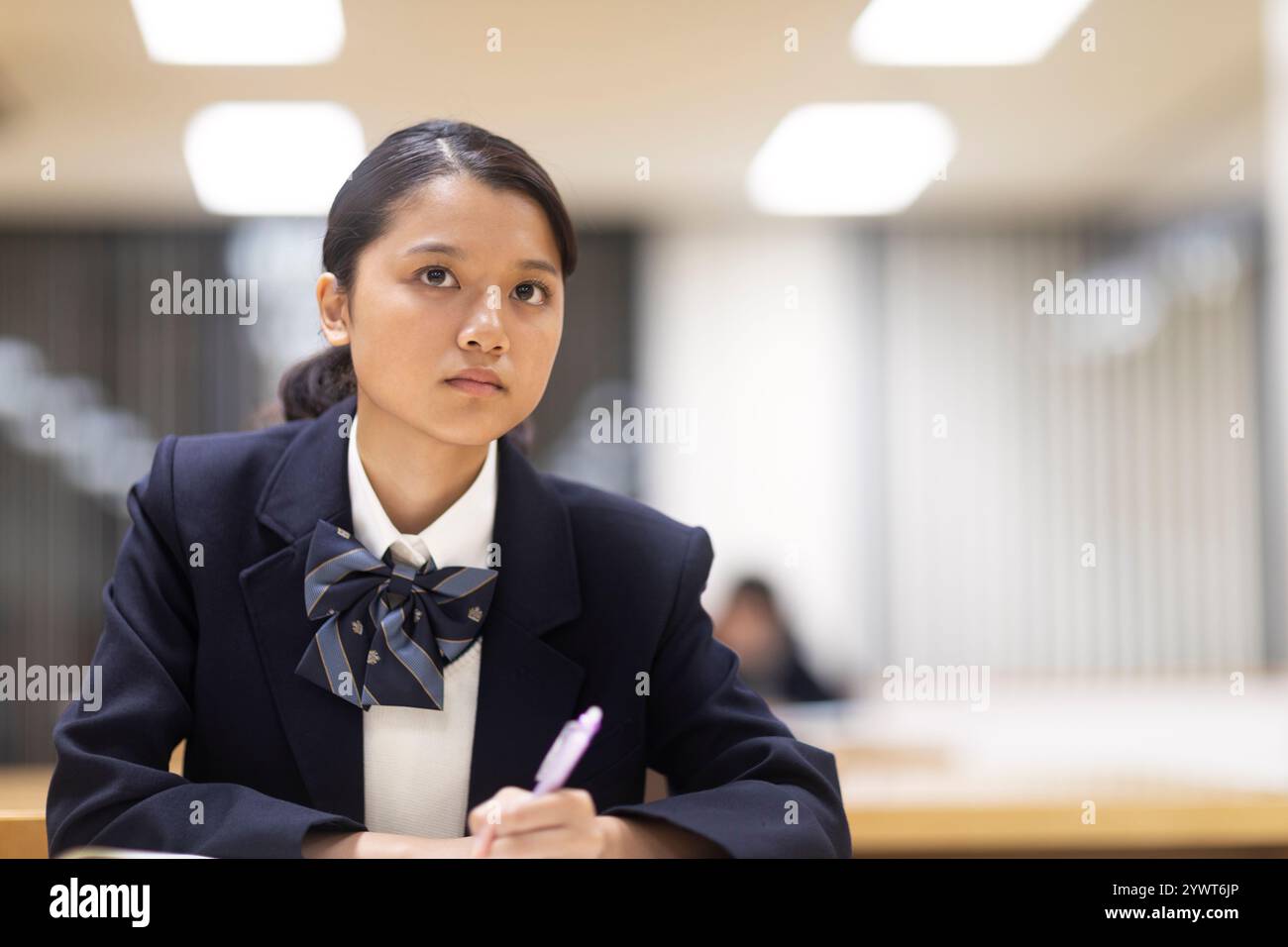 Female high school student looking up while studying Stock Photo - Alamy