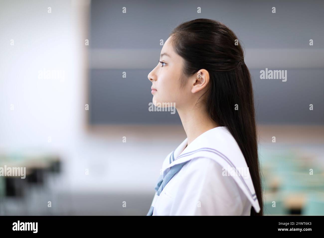 Female high school student standing in classroom in profile Stock Photo ...