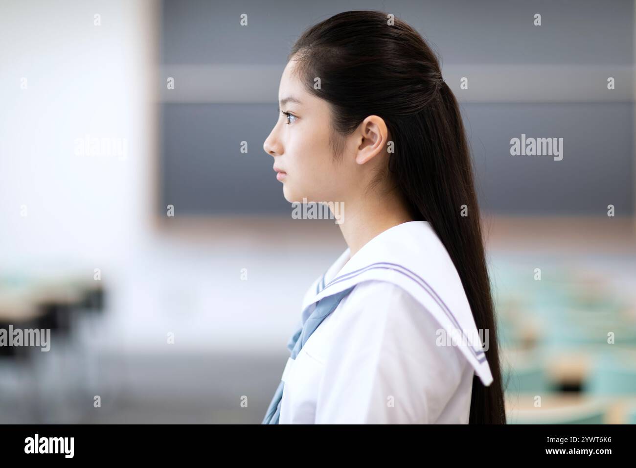 Female high school student standing in classroom in profile Stock Photo ...