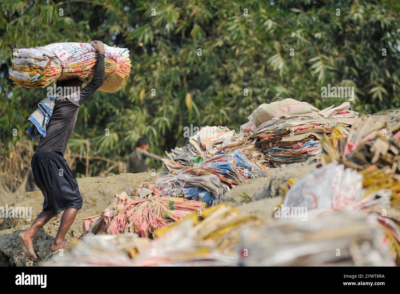 Workers washing cement bags in the water of Surma river and due to ...