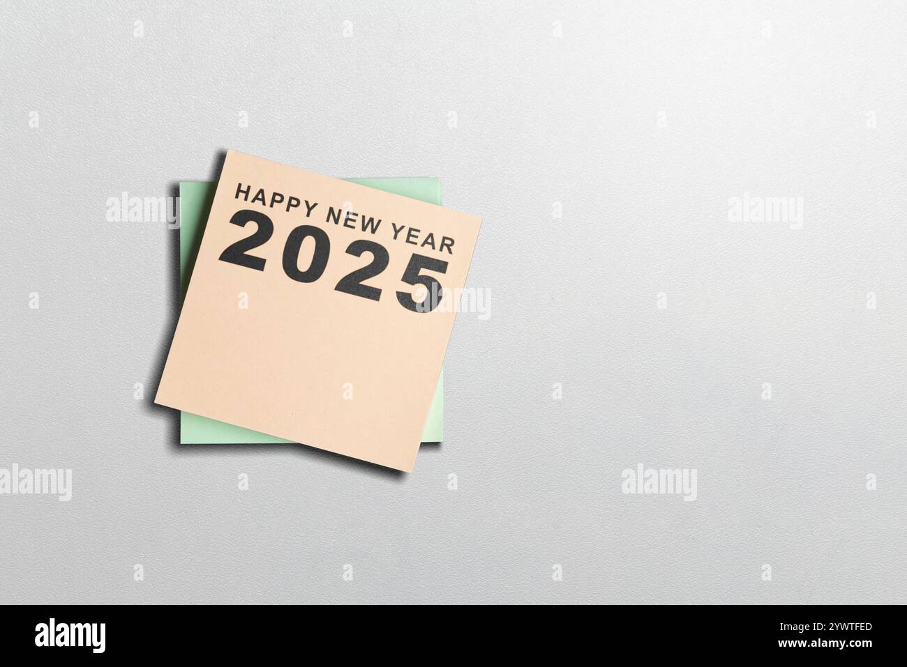 Top view of Happy New Year 2025 text written on a stack of notes paper ...