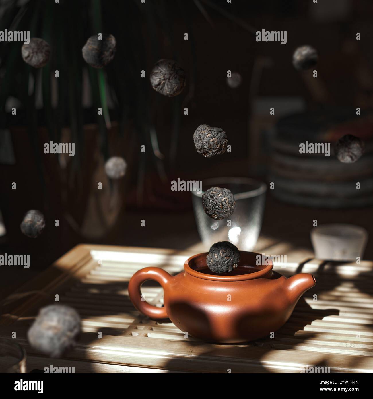 A collection of floating tea leaves gracefully hover above a teapot in ...