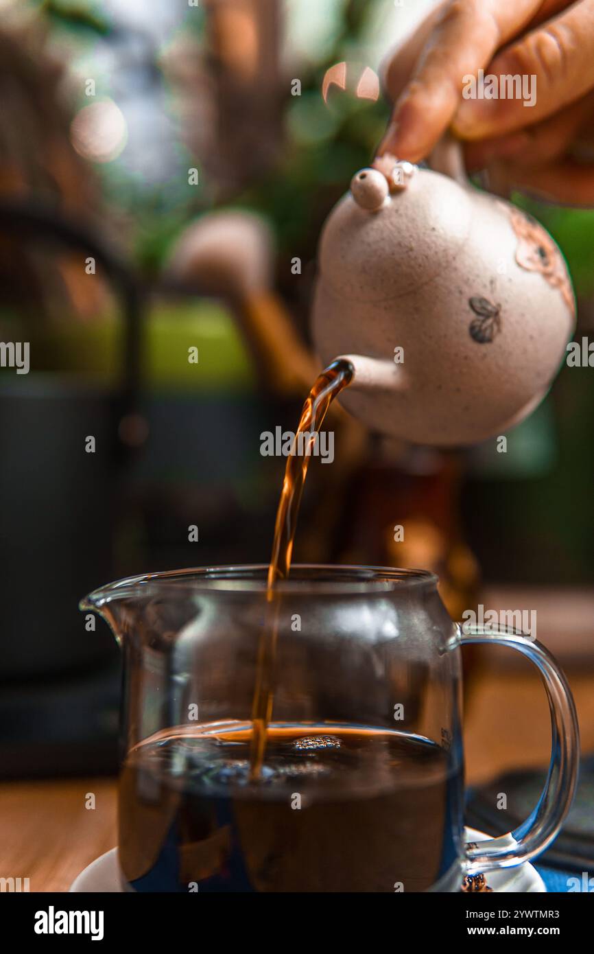 Traditional Teapot Pouring Tea into a Beautiful Glass Teacup for an ...