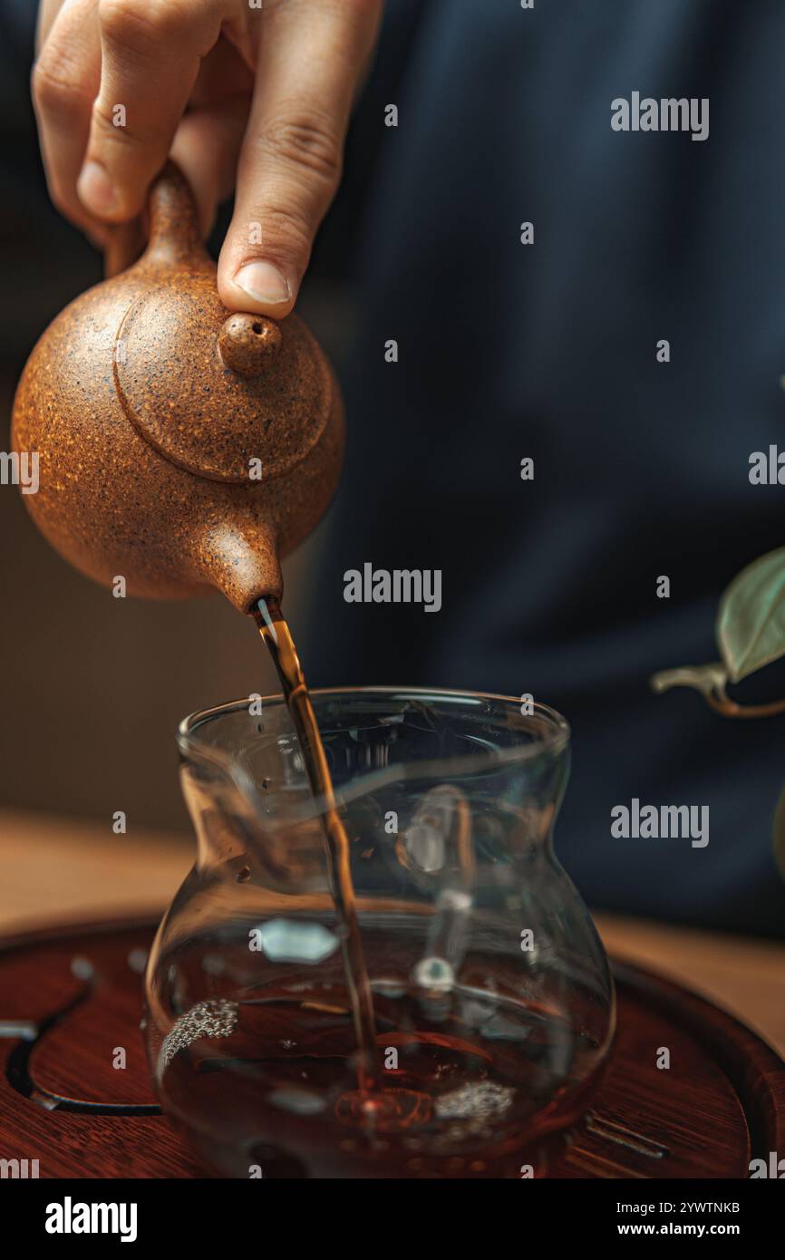 Experience the delicate art of pouring tea from a traditional ceramic ...