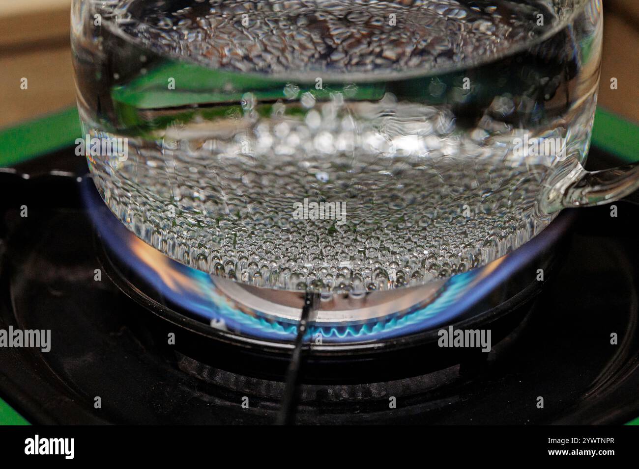 Water is boiling on the stove with bubbles steadily rising from the ...