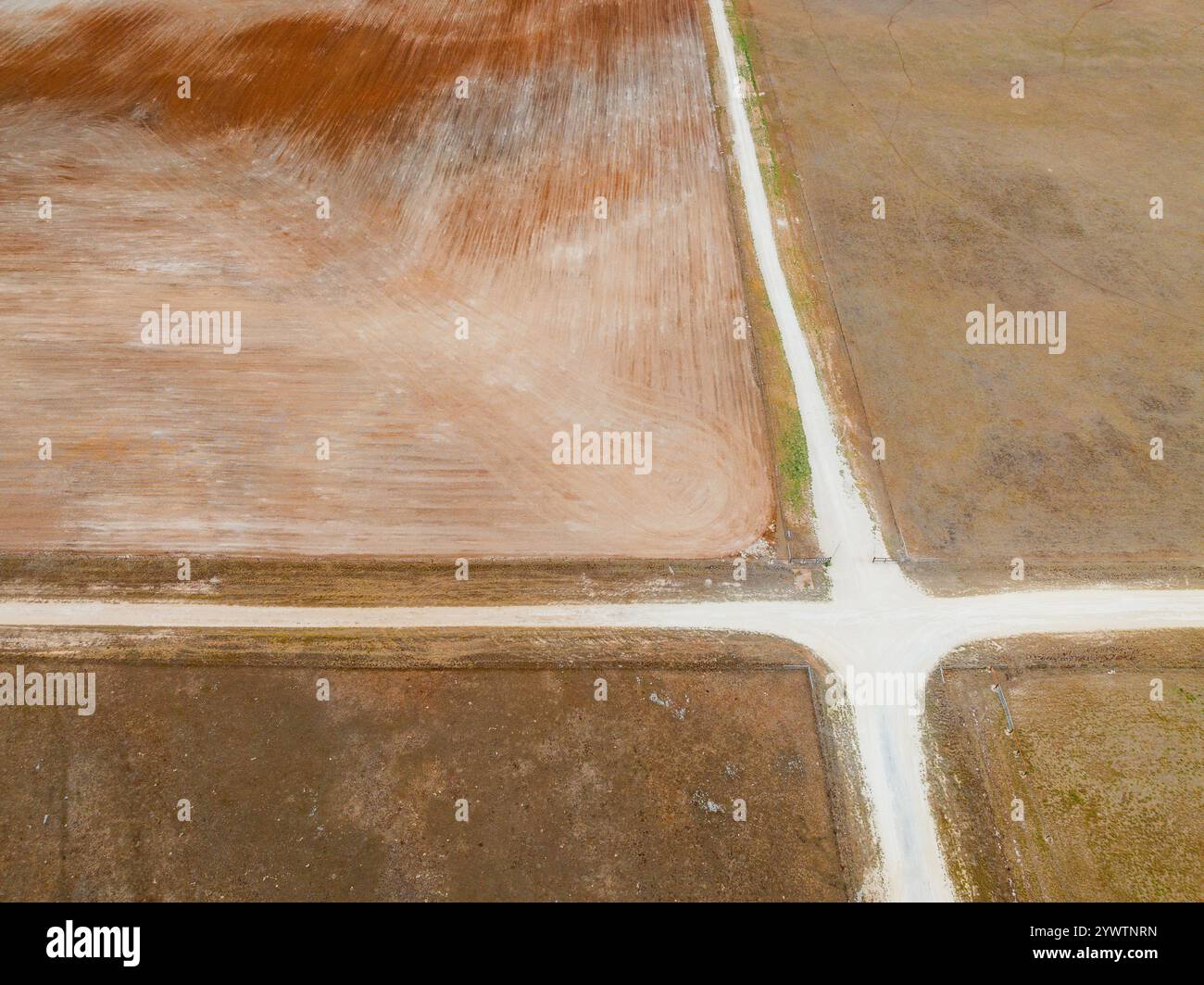 Aerial view of two dirts roads intersecting in the middle of barren ...