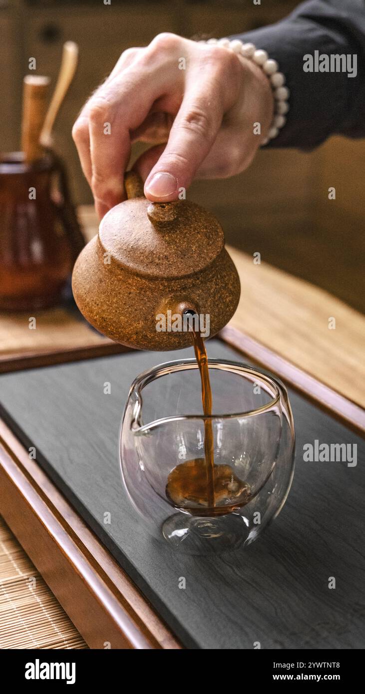 Experience the serene and elegant ritual of pouring tea from a ...