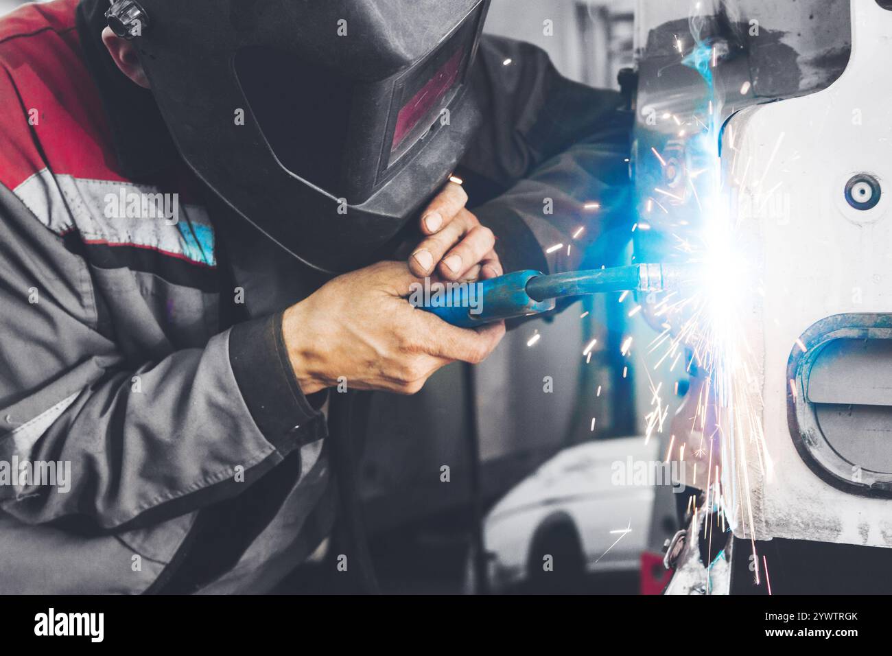 Working with carbon dioxide welding to fix metal body. Repair service ...