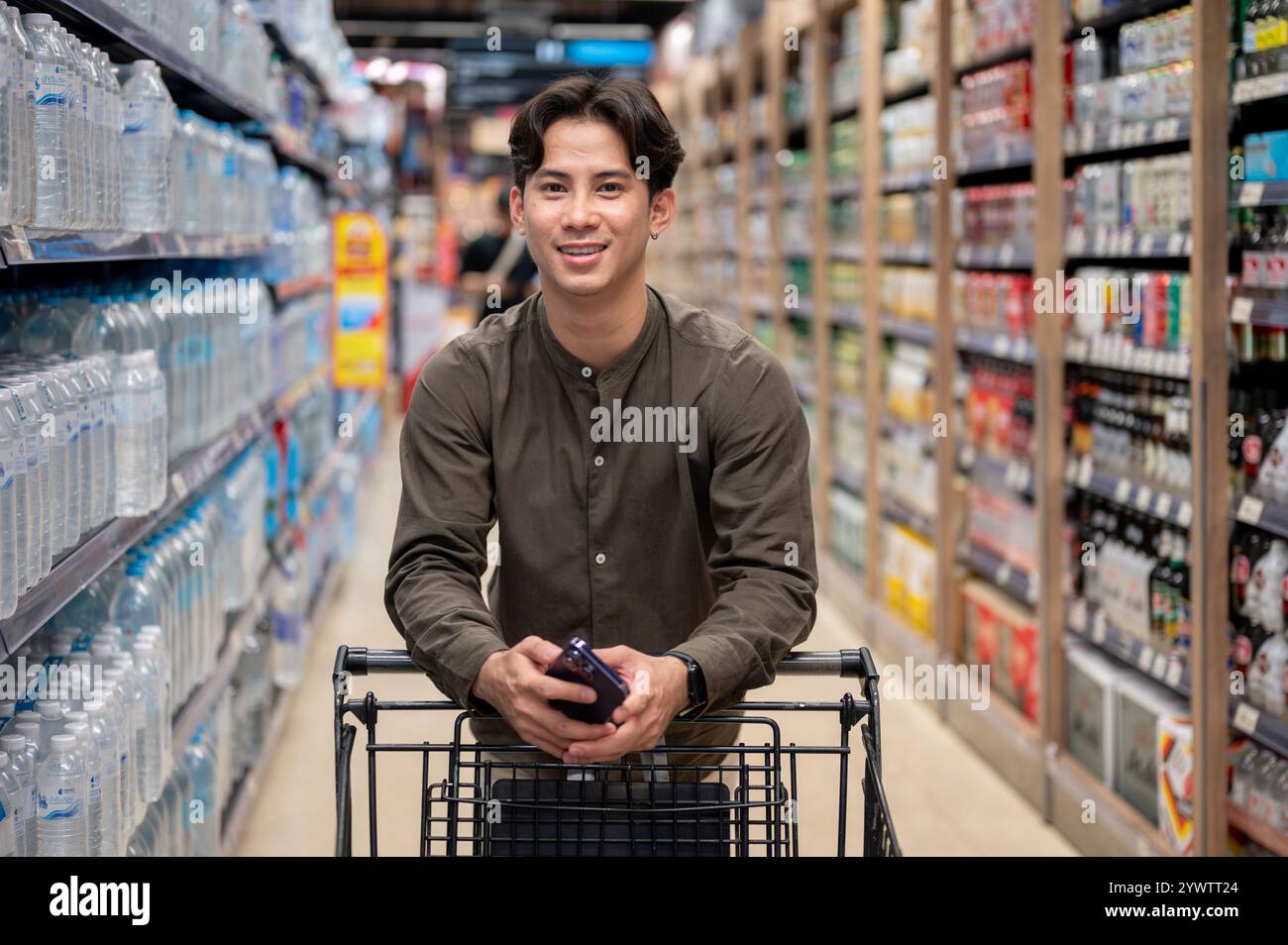 Chiang Mai, Thailand - Dec 09 2024: A smiling, handsome young Asian man shopping at a ...