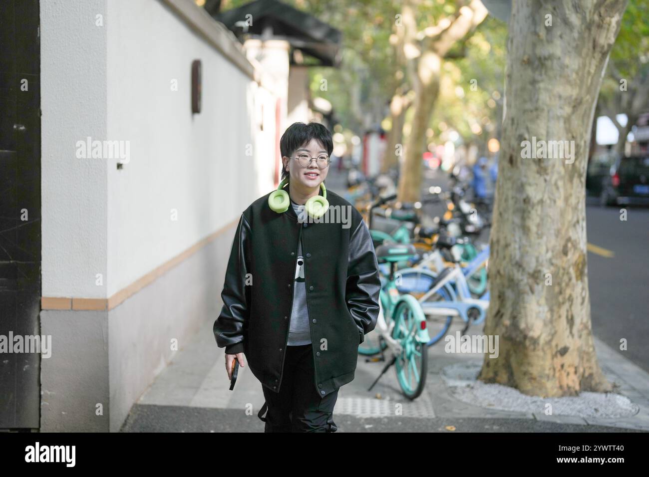 A Chinese woman in her 30s in sporty clothes walks along Jilu Road in ...