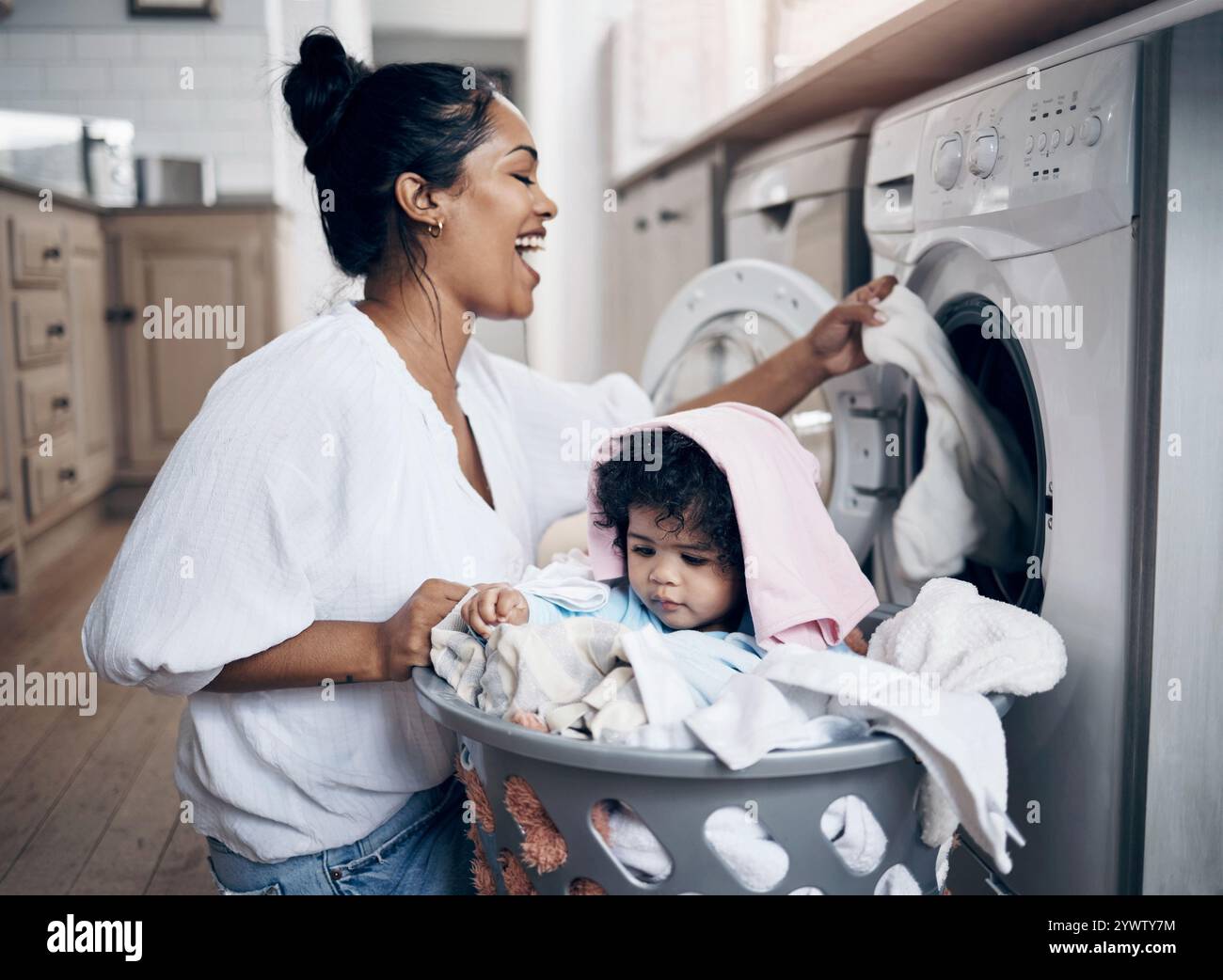 Mother, infant and playing with laundry in home, help mom and ...