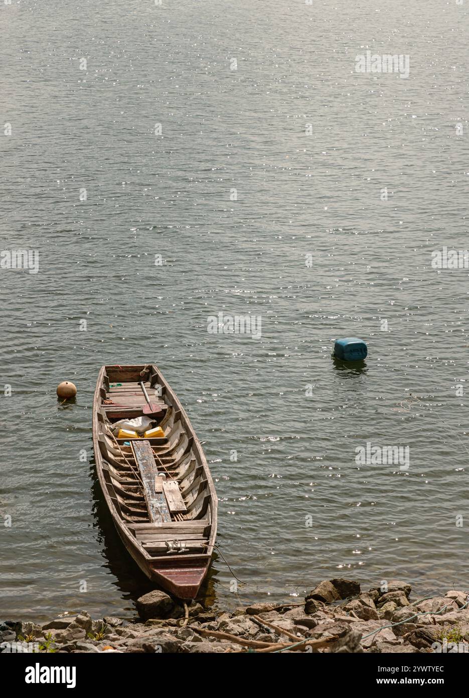 Traditional hand built small wooden rowboat slowly in warm evening ...
