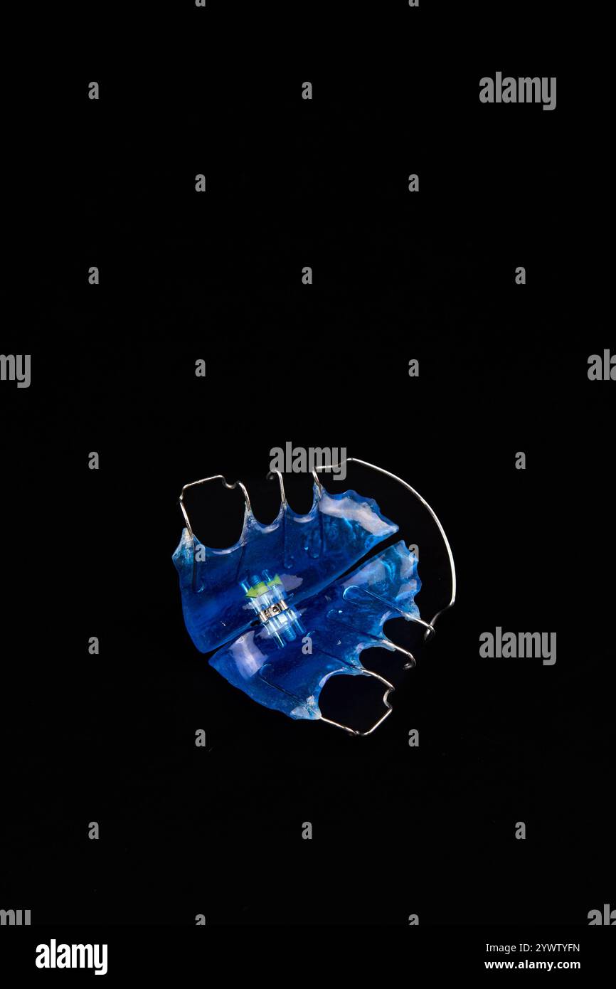 Blue orthodontic appliance to open the child's palate, on a black ...