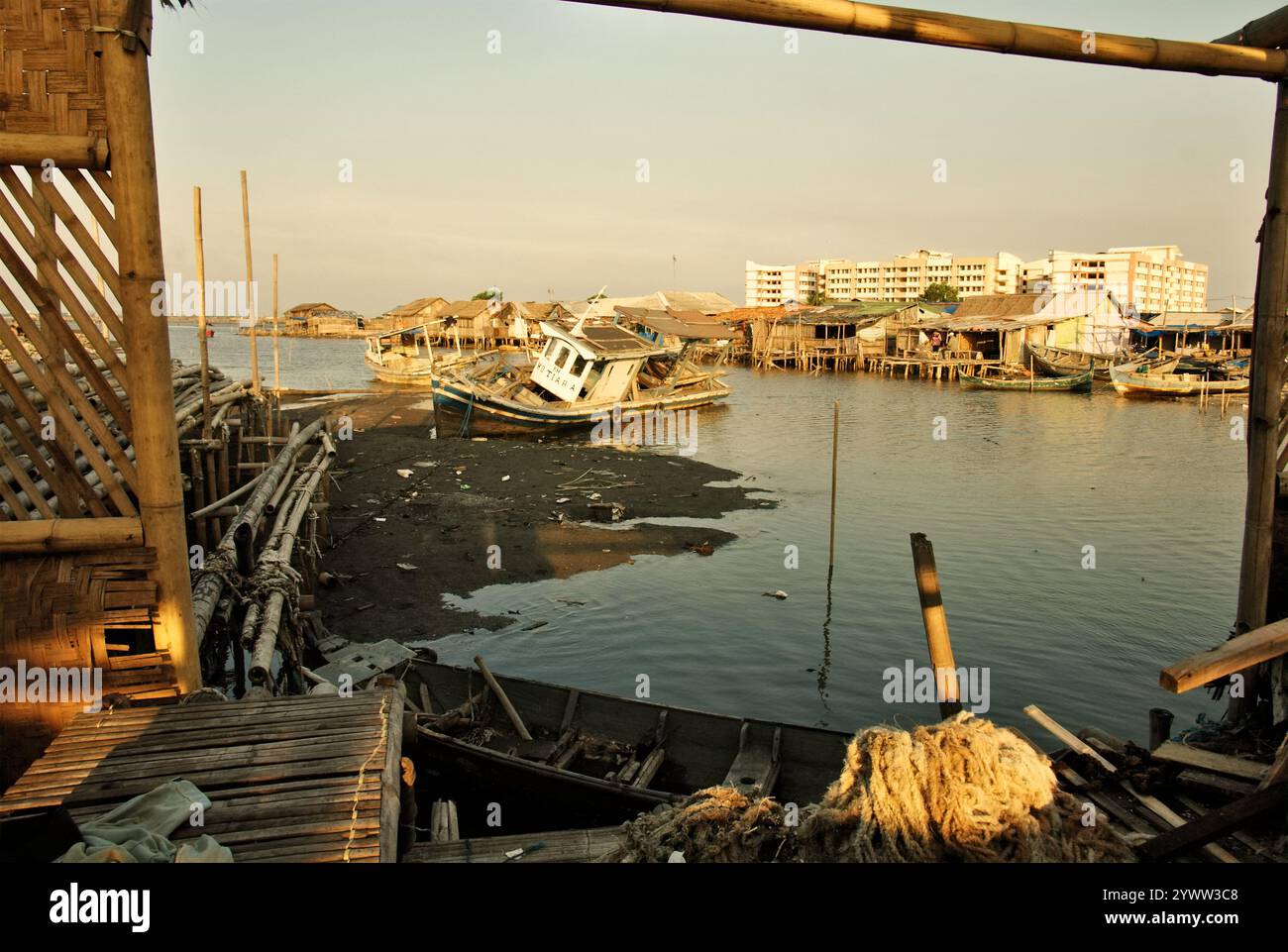 Intertidal beach and stilt houses in a background of new flat buildings ...