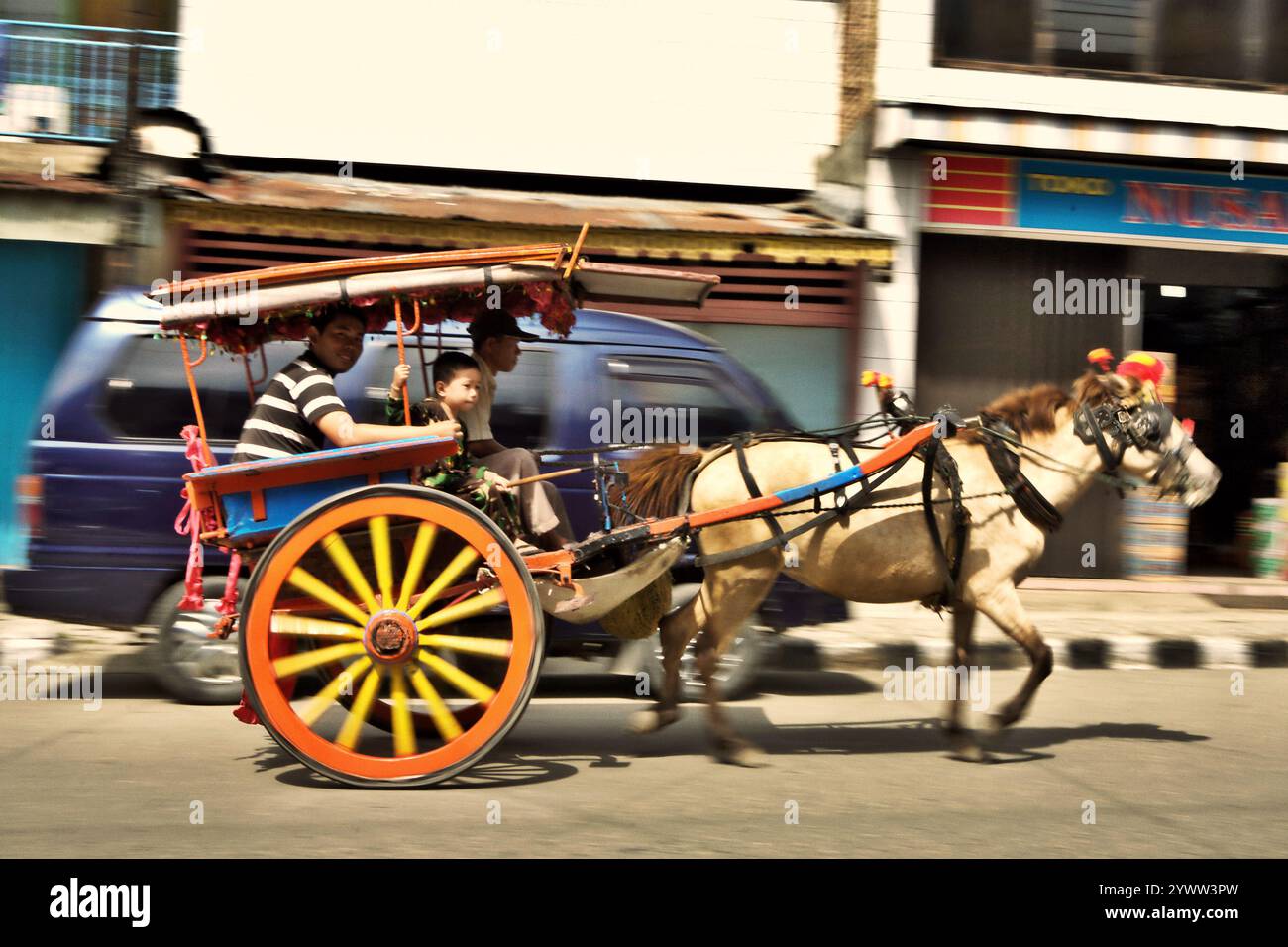 A horse-pulled rickshaw carrying passengers, moving on a road in Sungai ...