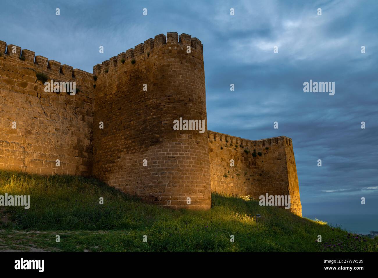 The tower and wall of the ancient fortress of Naryn-Kala in the cloudy ...