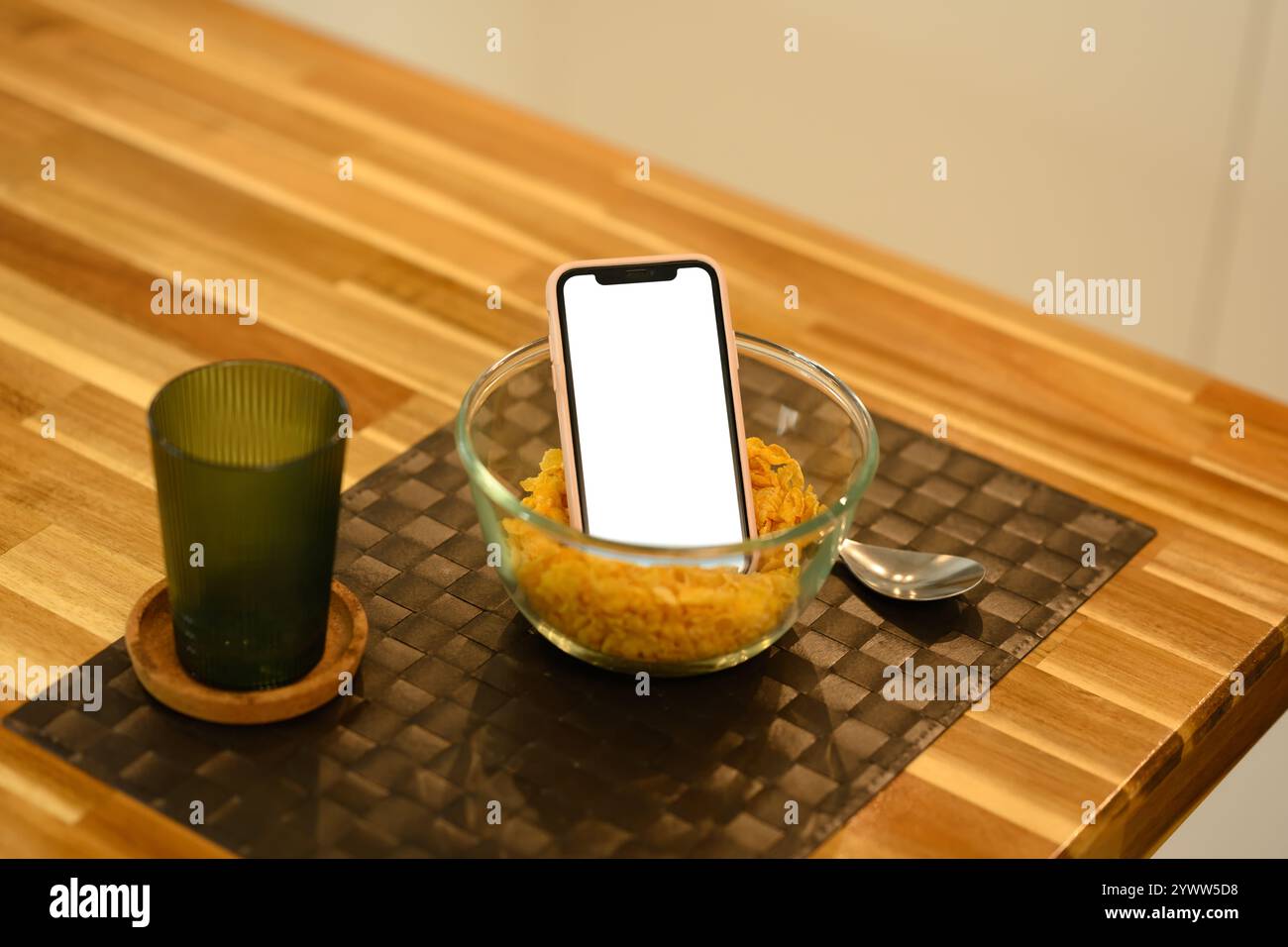 Smartphone with white screen in a bowl of cornflakes on kitchen table ...