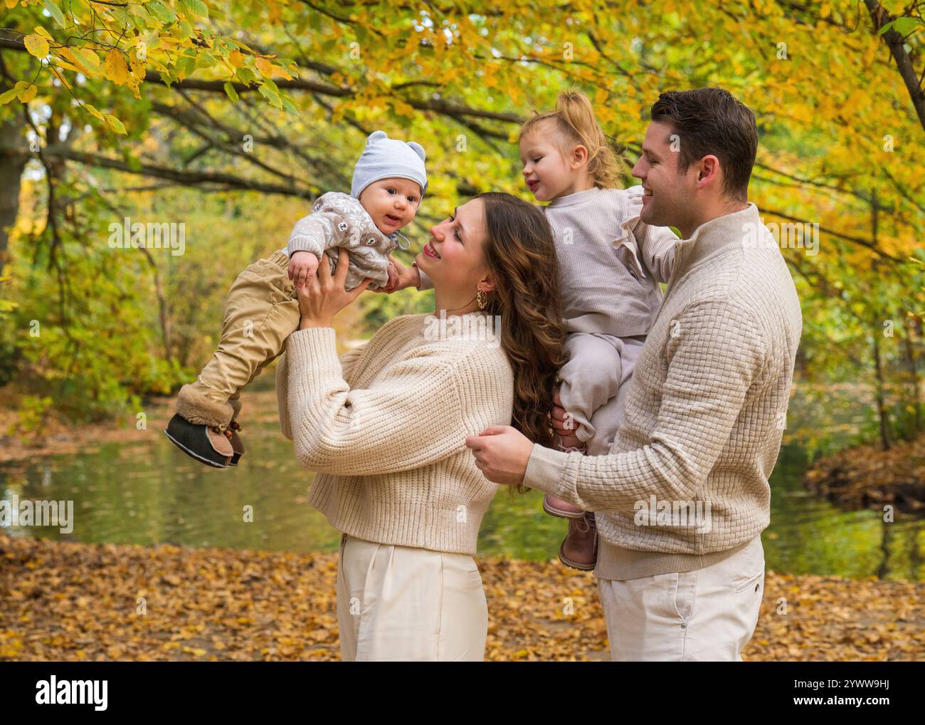 Happy parents with two children. Mom and dad holding baby son and girl ...