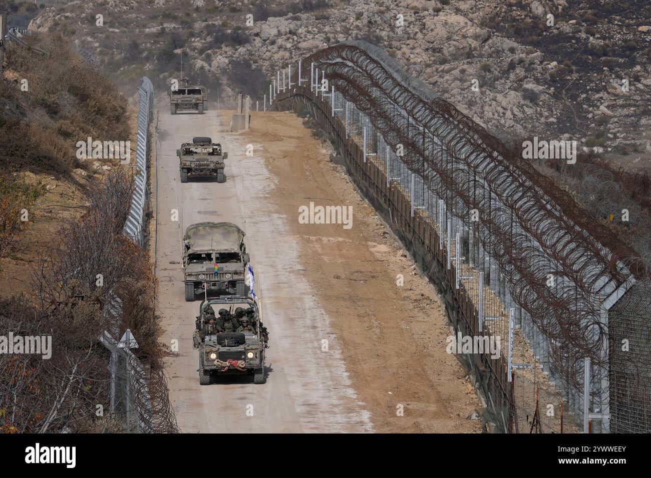 Israeli armoured vehicles maneuver after crossing the security fence ...