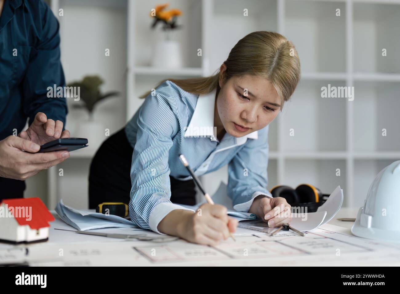 Engineer and architect collaborate on blueprint designs in modern ...