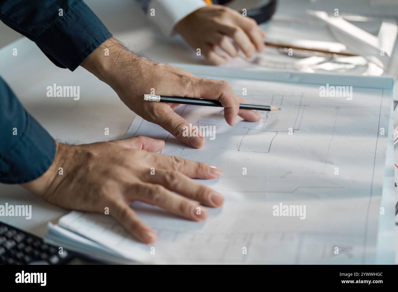 Engineer and architect reviewing blueprint plans in an office ...
