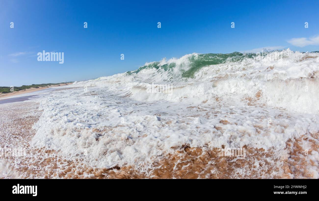 Beach ocean waves crashing onto shore break sand with white blue water ...