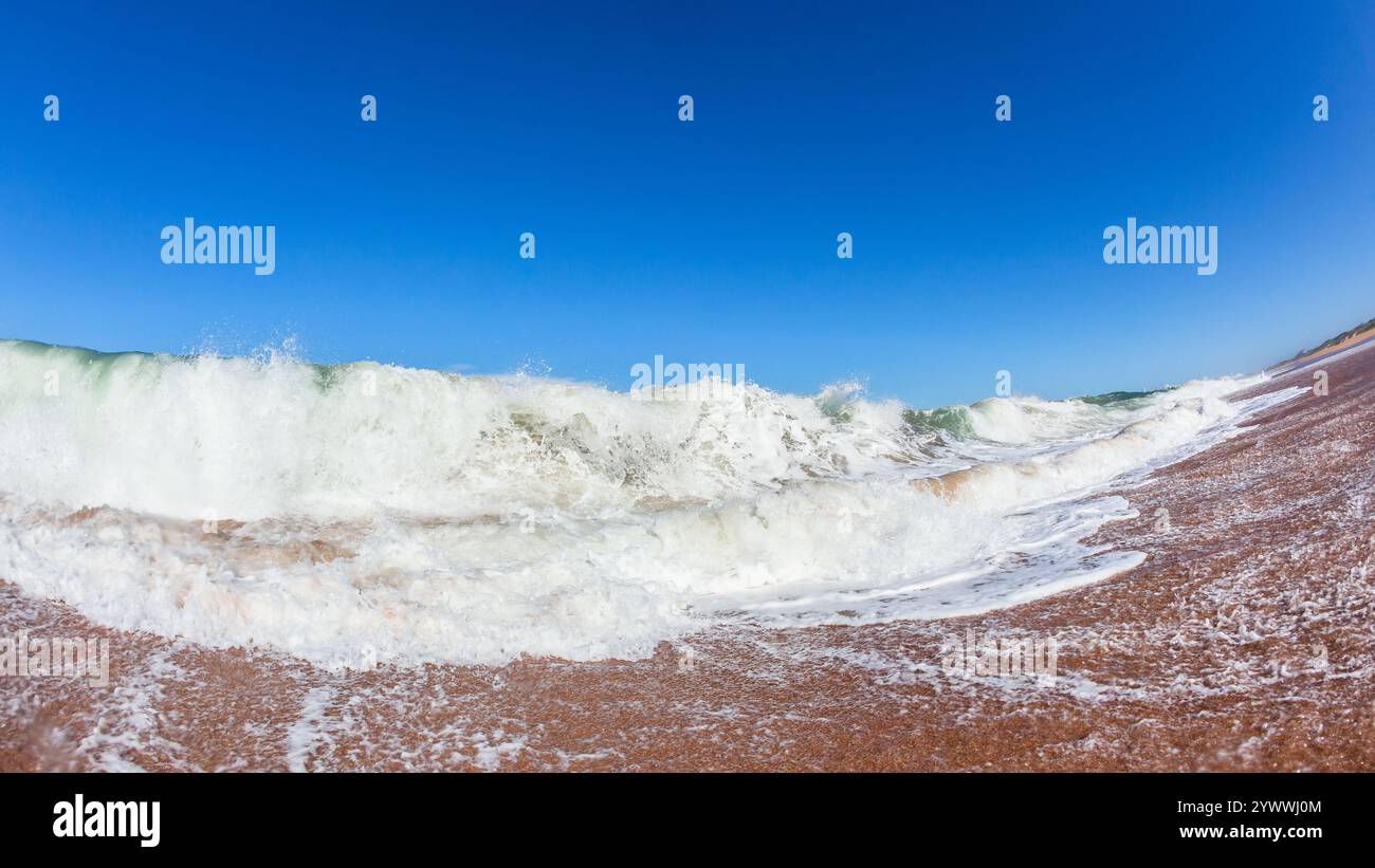 Beach ocean waves crashing onto shore break sand with white blue water ...